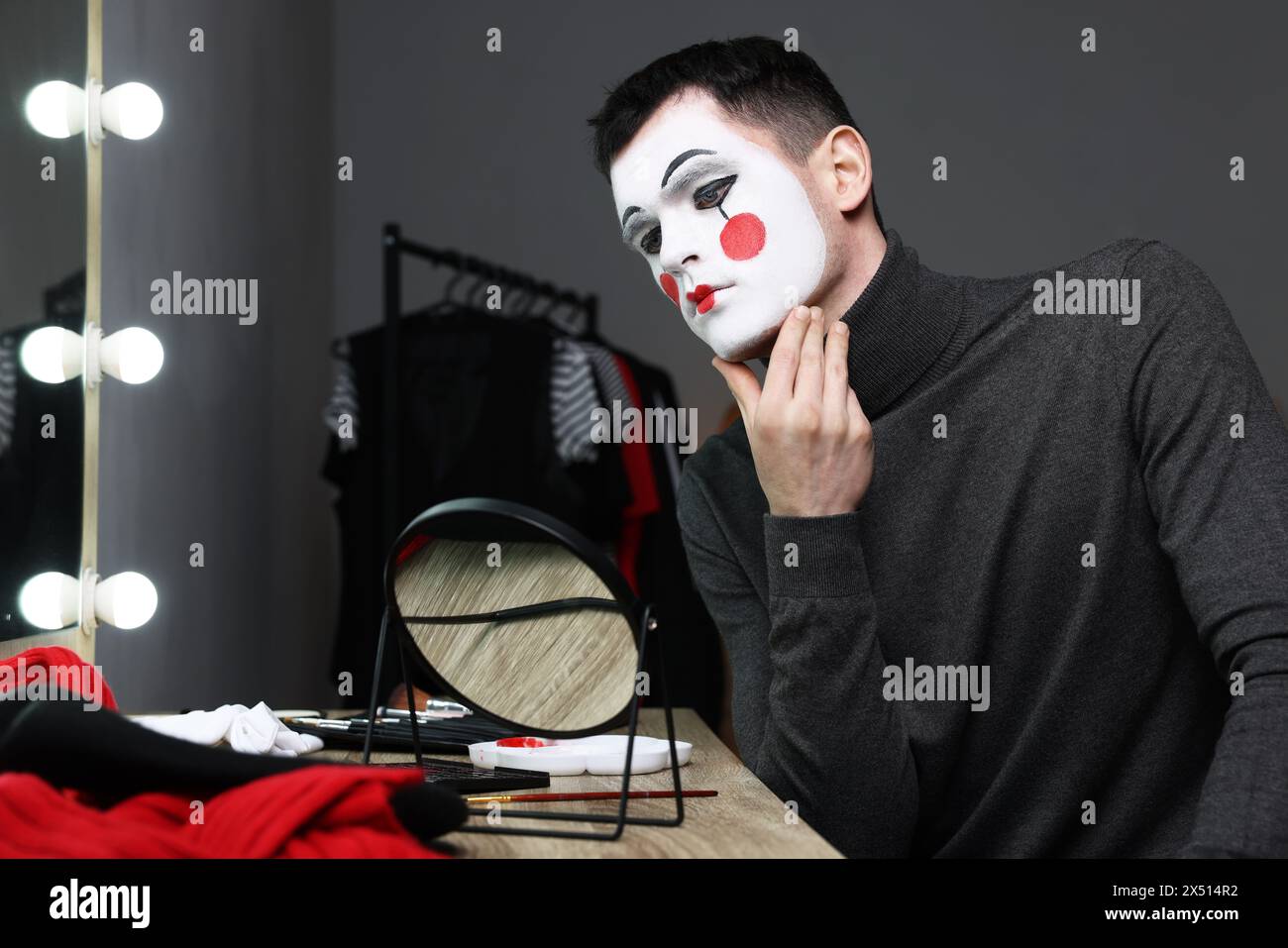 Mime artist looking at mirror in dressing room Stock Photo - Alamy