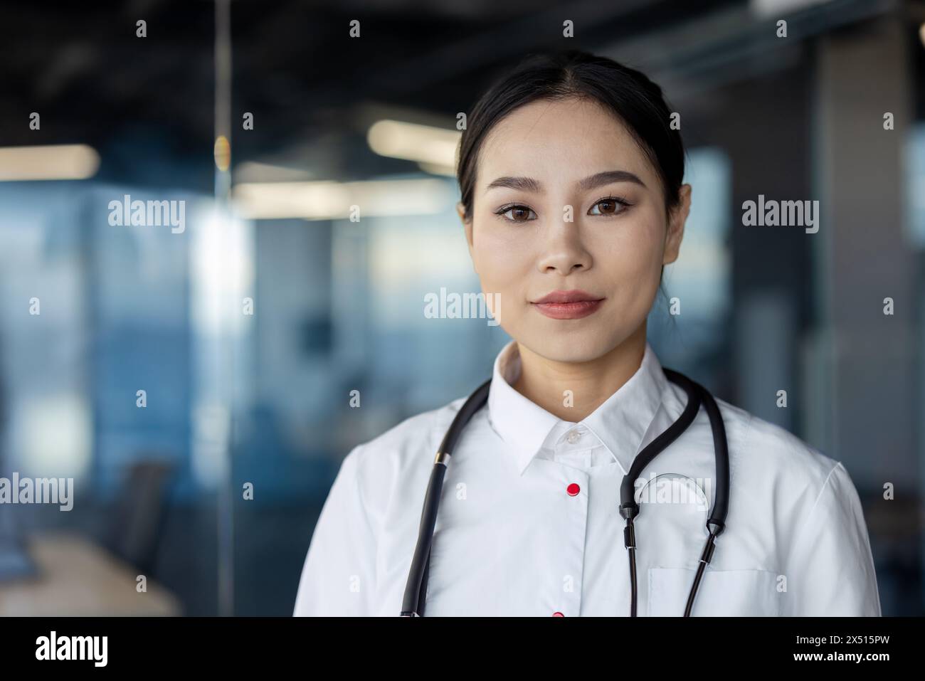 Portrait of a serious Asian female doctor with a stethoscope, standing ...