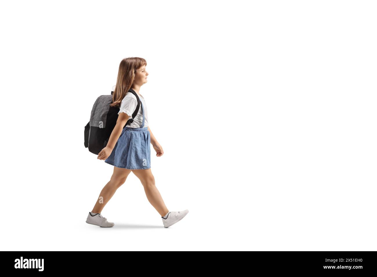 Full length profile shot of a little girl with a backpack walking ...