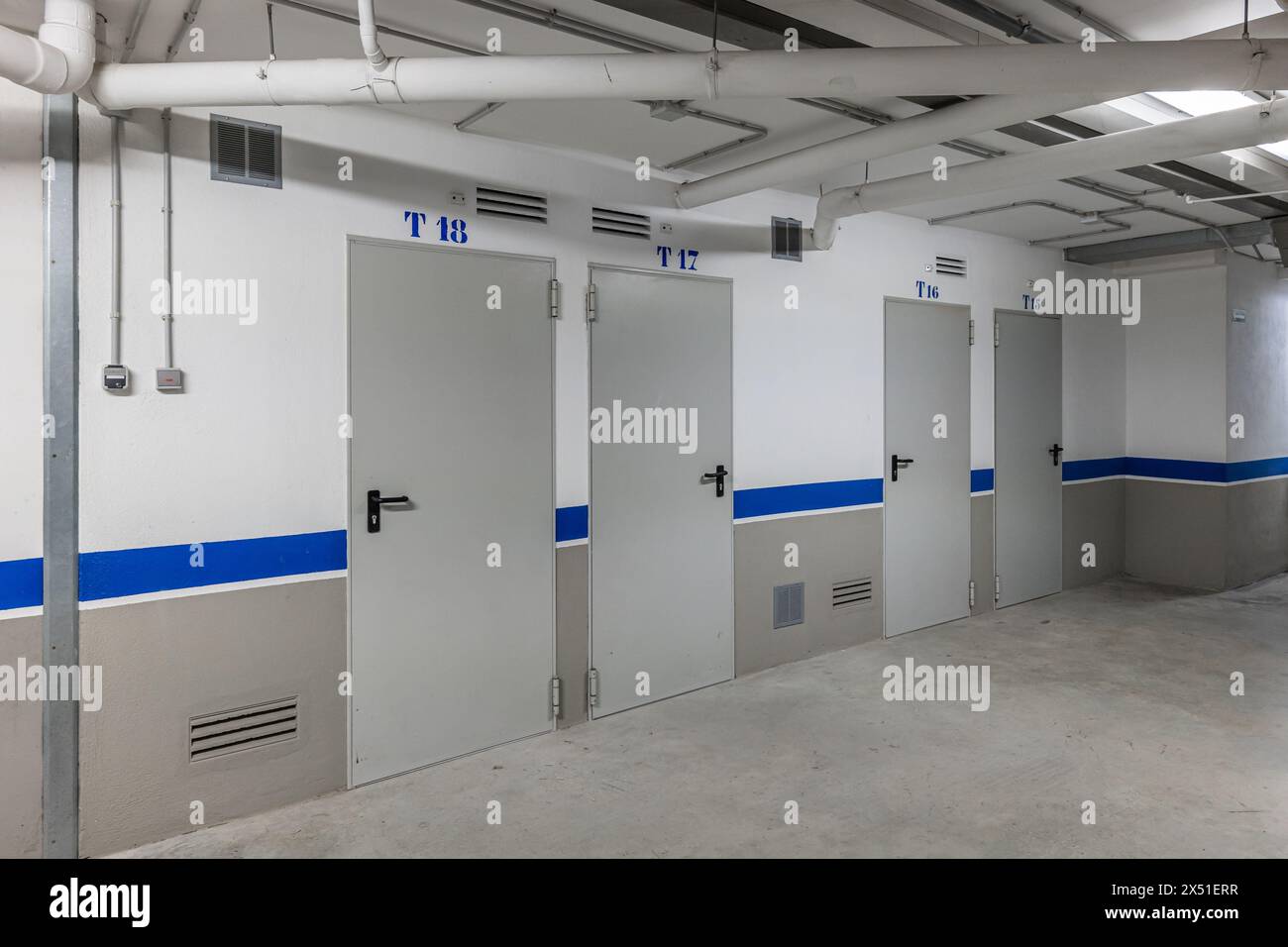 Modern storage facility with numbered white storage doors and blue ...
