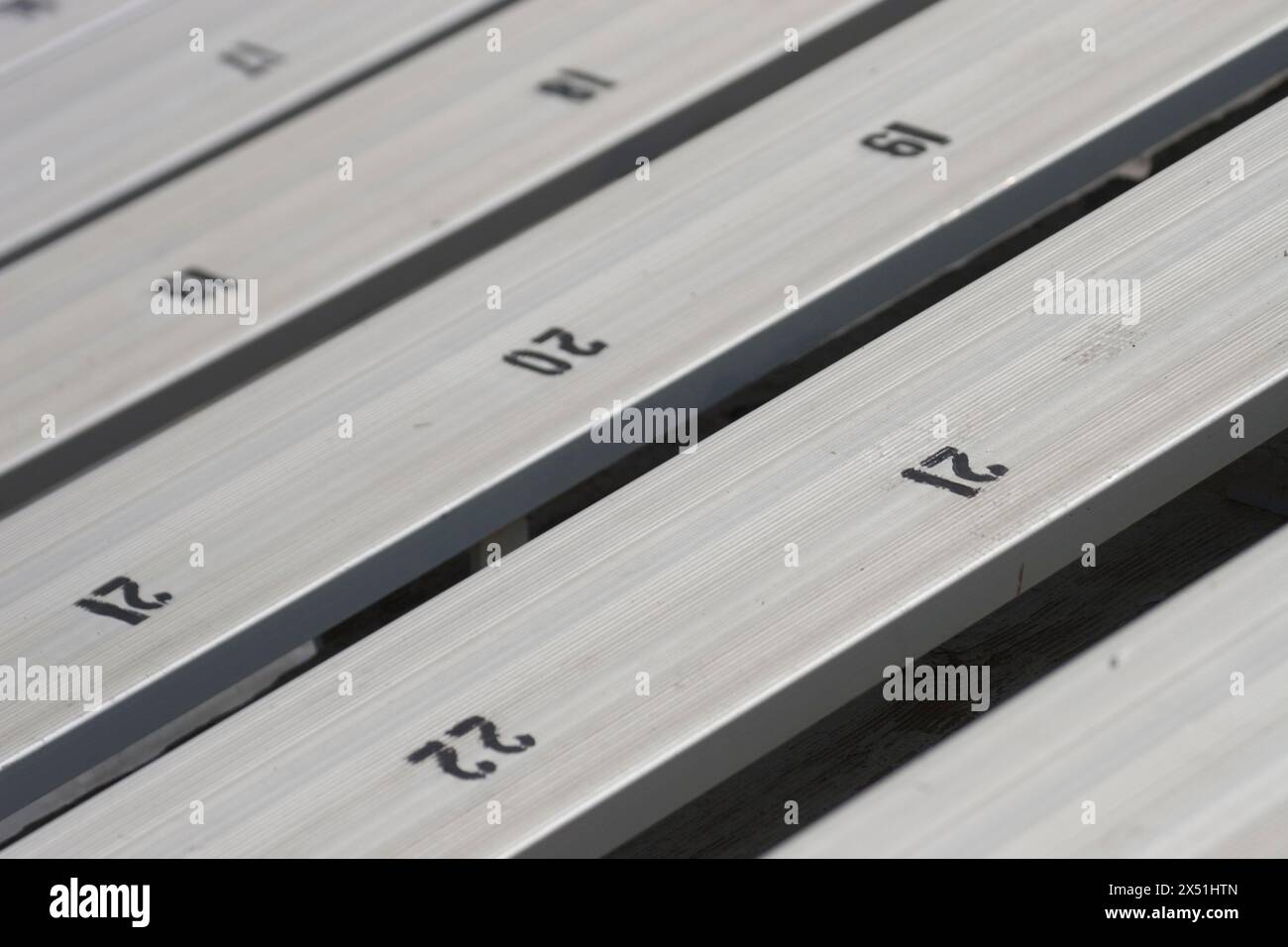 Seat numbers marked on aluminum grandstand seats Stock Photo - Alamy