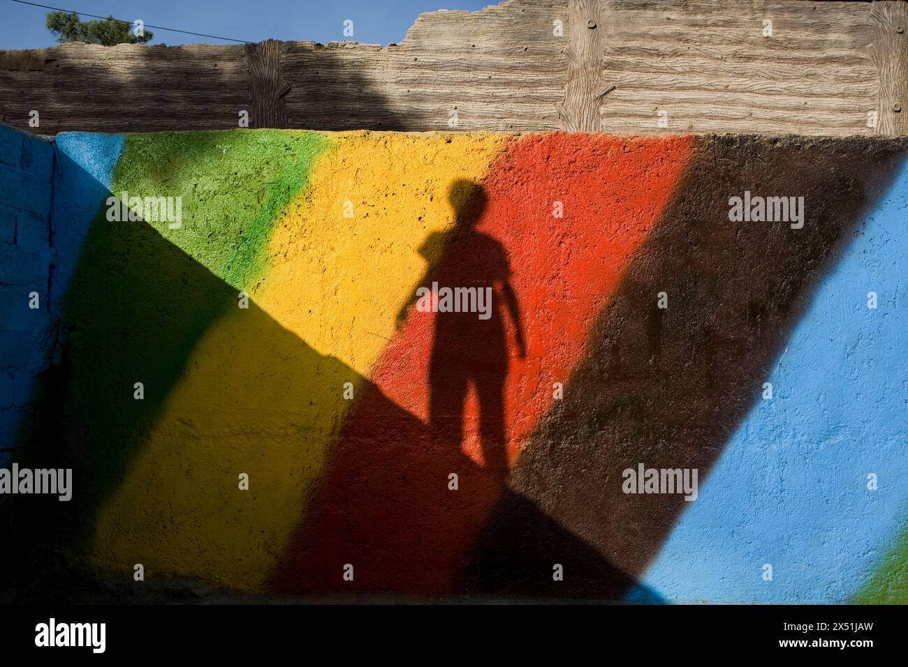 A Iranian boy casts a shadow on a colorful wall Stock Photo - Alamy