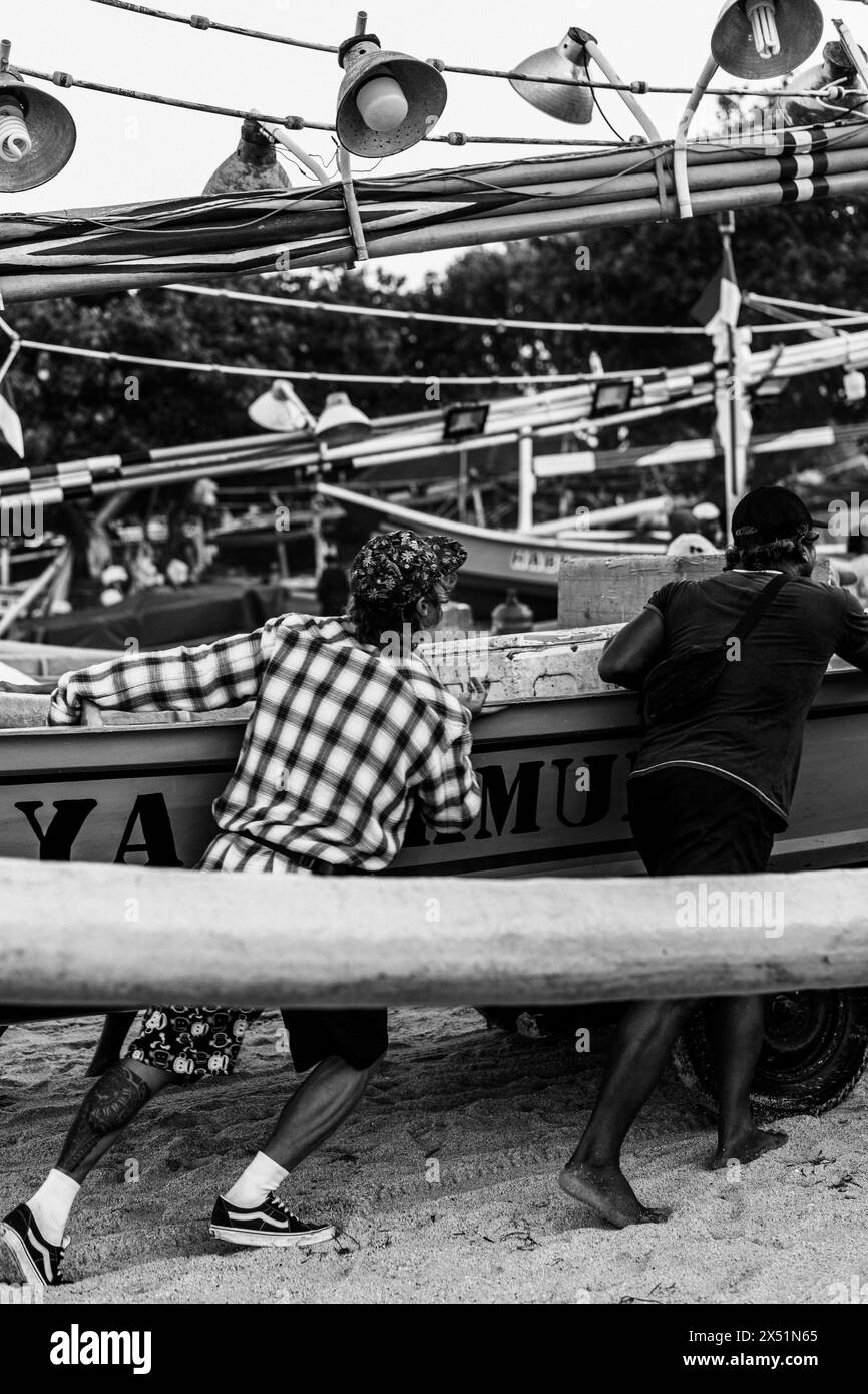 Fishermen roll out a fishing boat from the water to the shore Stock ...