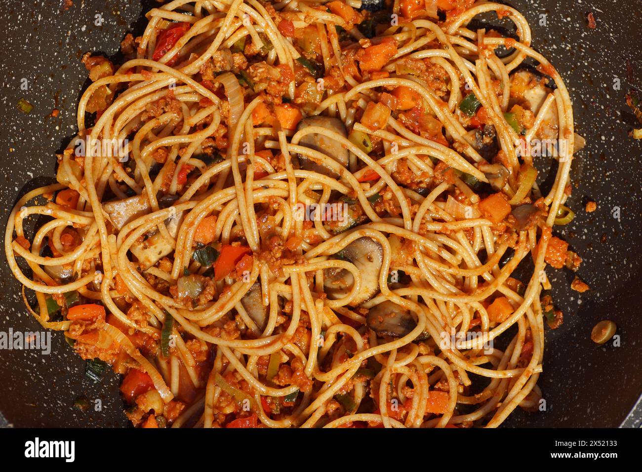 Close up spaghetti in a wok with vegetables, tomatensauce, peppers ...