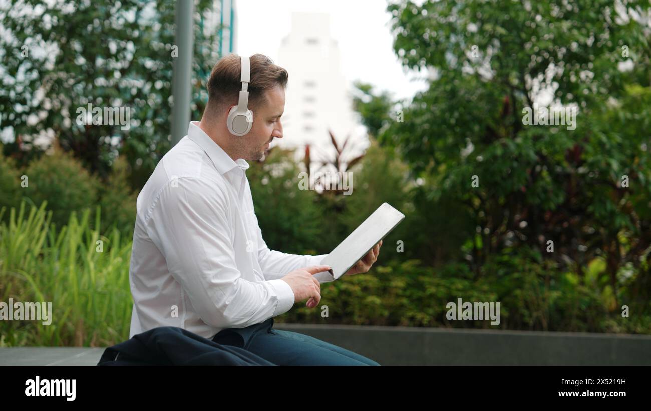 Businessman wear his headphone to listen relaxed music while take off ...