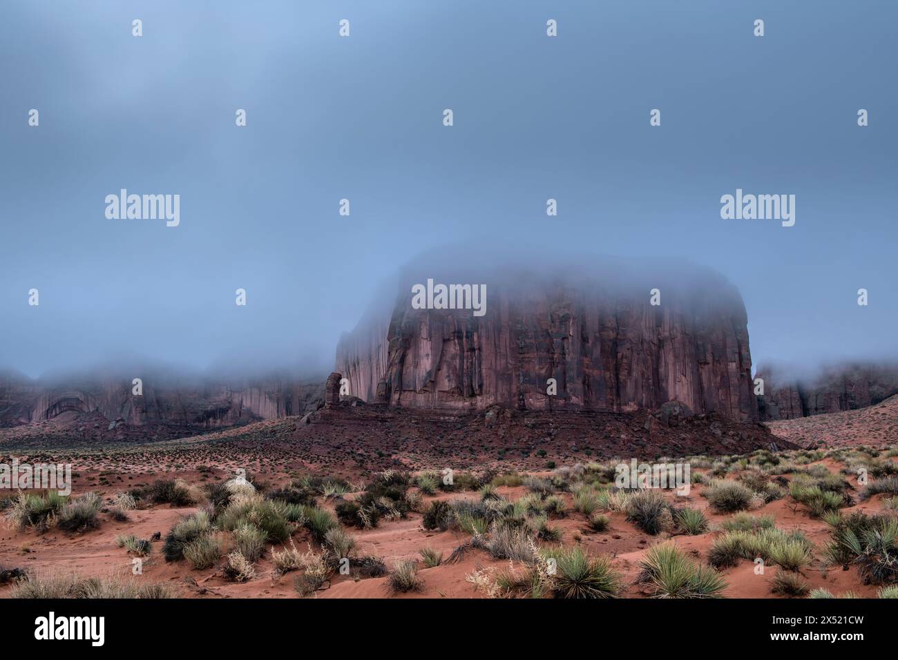 Low rainclouds hug a butte in Monument Valley's Navajo Tribal Park as ...