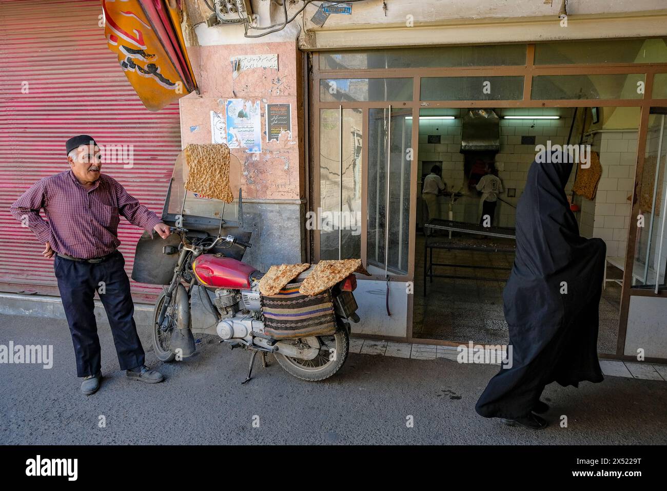 Qom, Iran - April 6, 2024: A man buying bread at a bakery in Qom, Iran ...