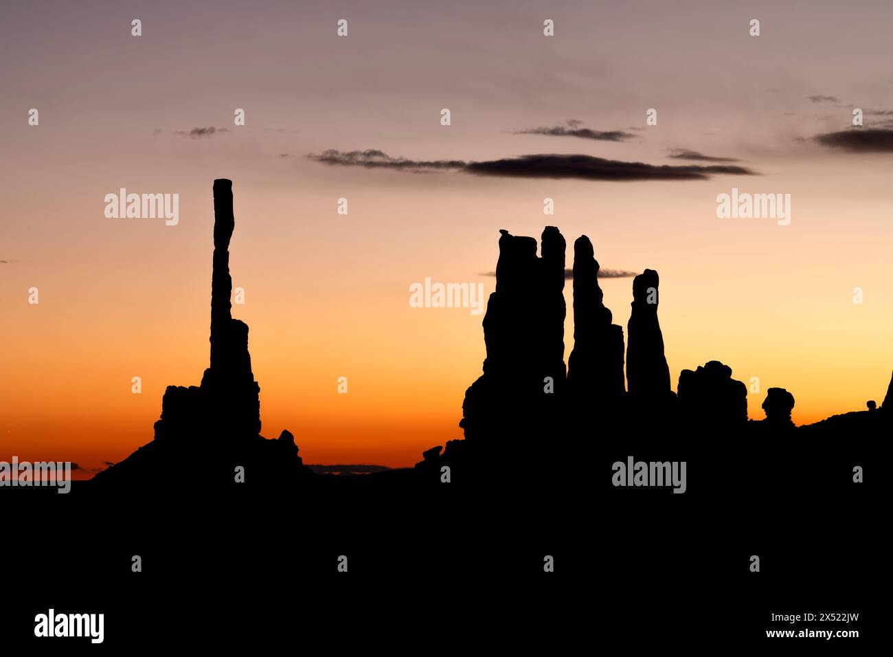 Sunrise behind Monument Valley's famous totem pole and nearby spires ...