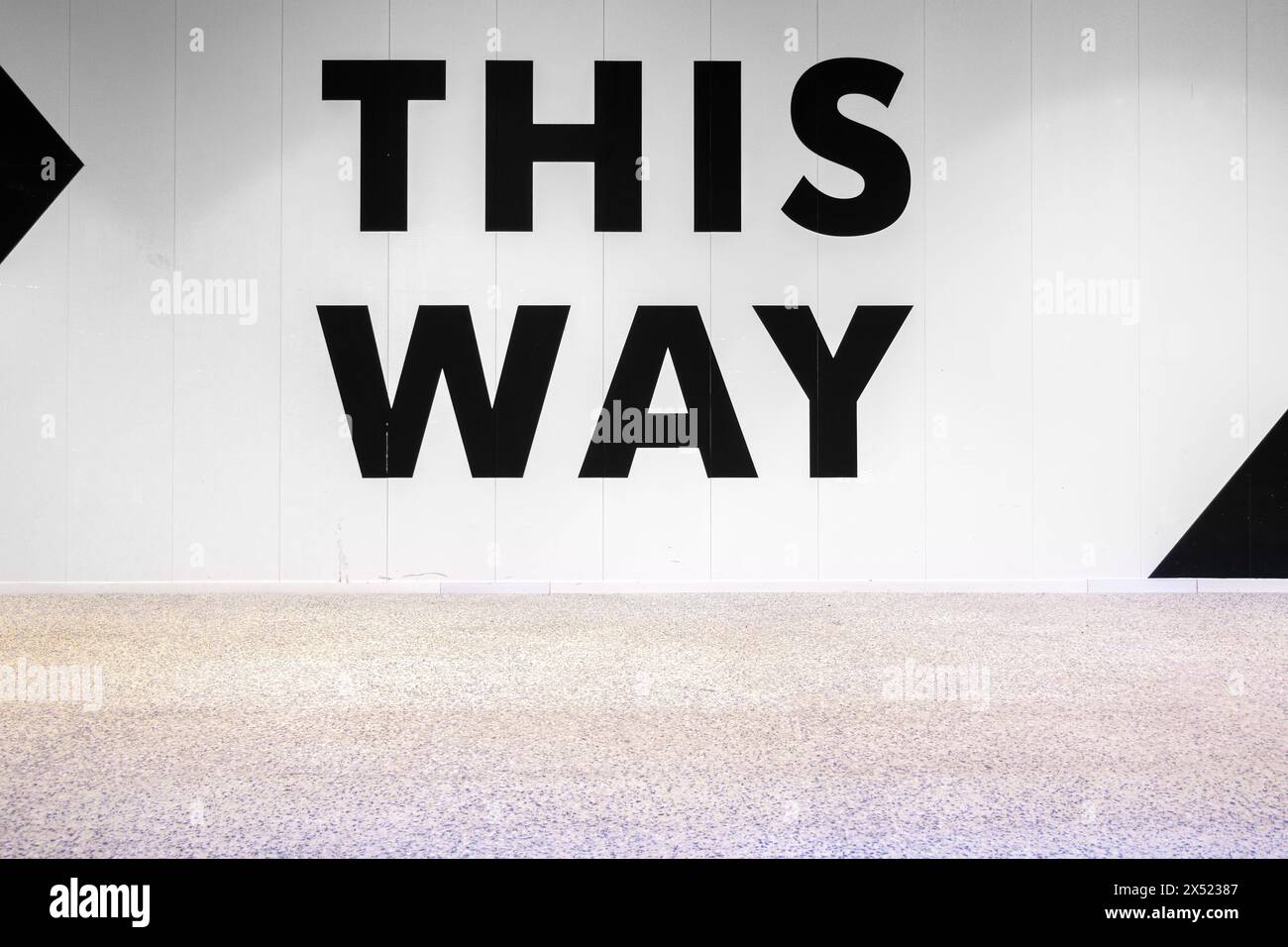 The inscription on the white wall: This way. Direction indicator Stock ...
