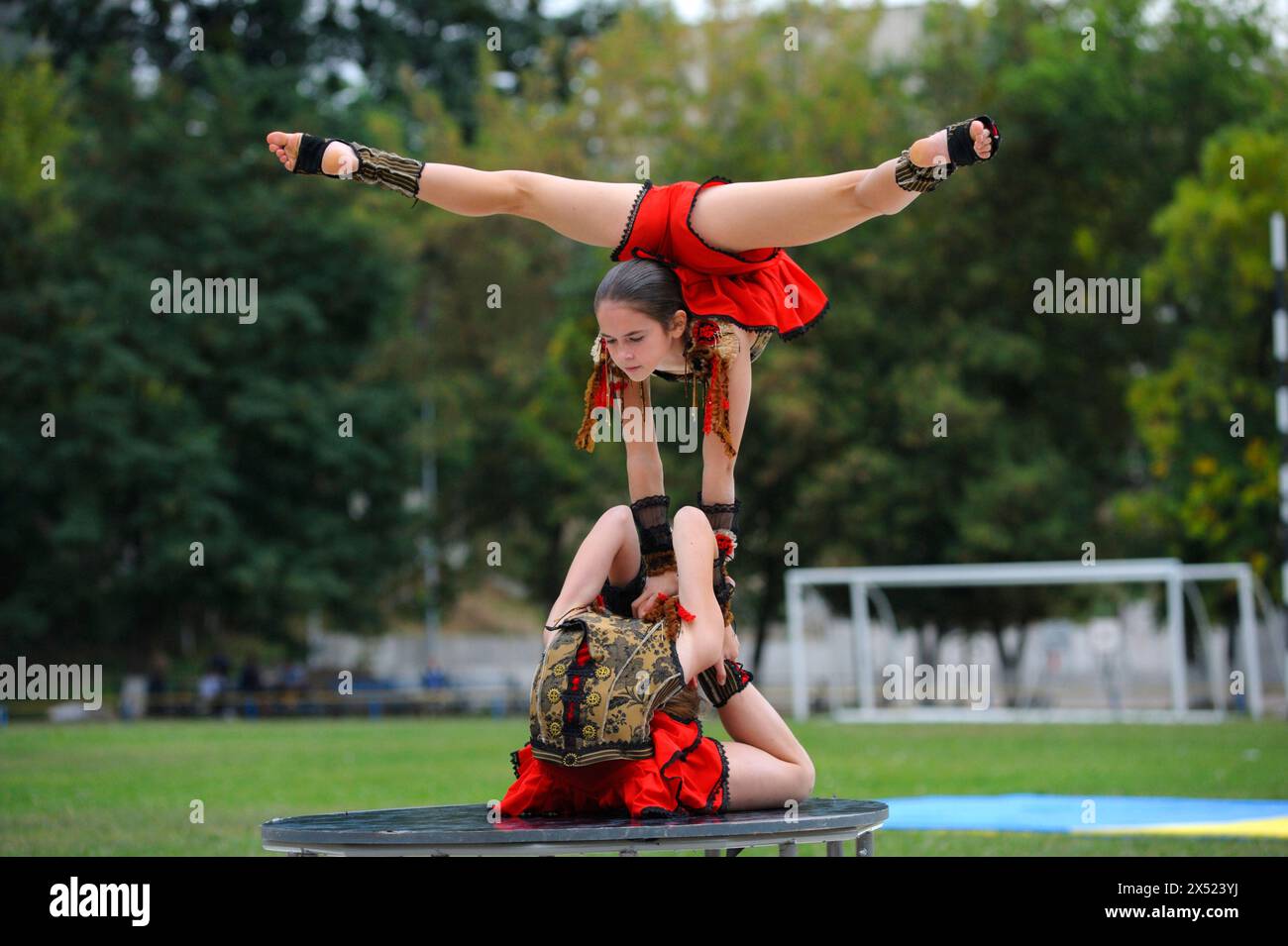 Teens girls acrobats performing acrobatic stunt on a stadium. June 20 ...