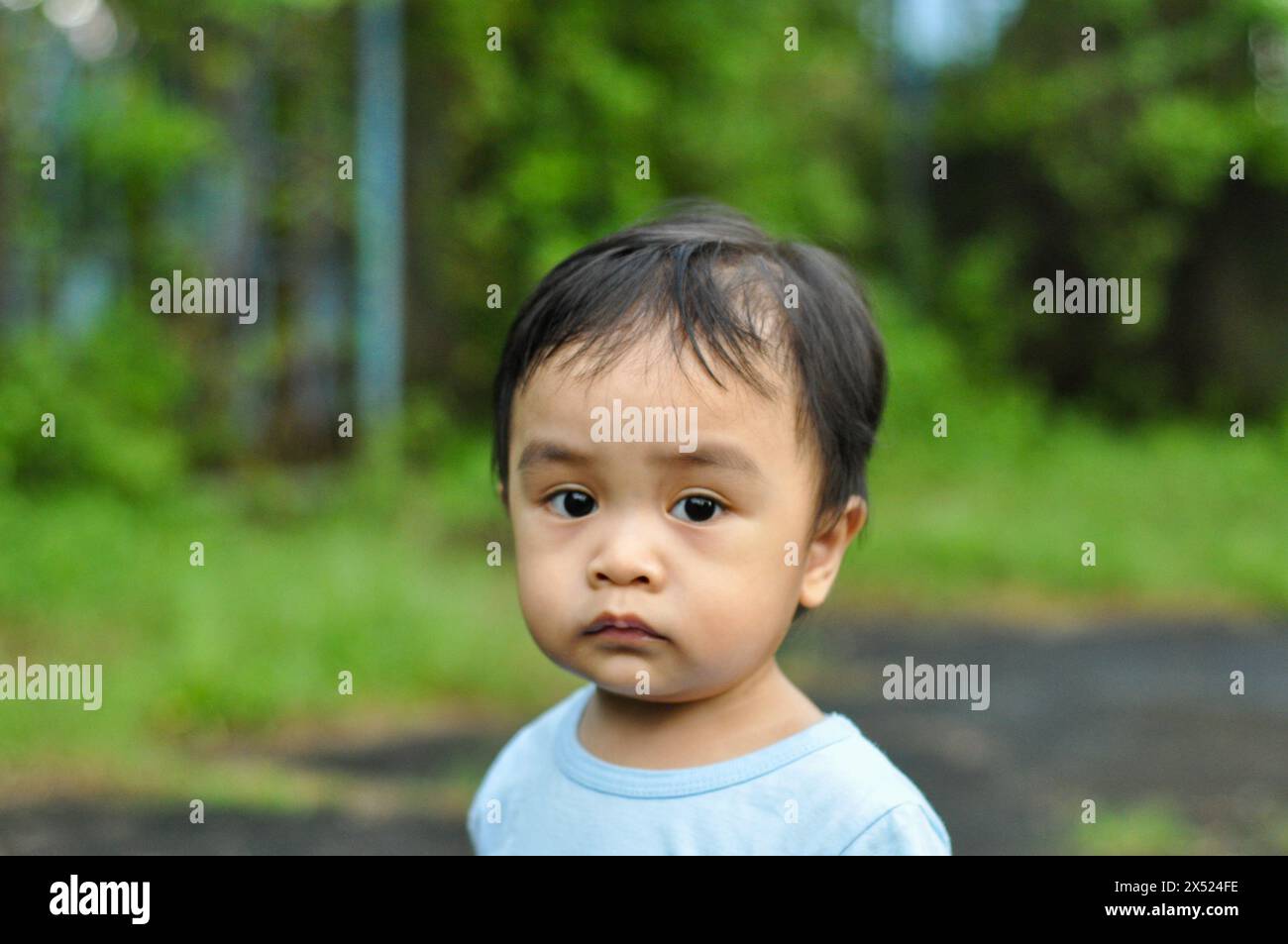Adorable Indonesian toddler portrait while playing outdoor Stock Photo ...