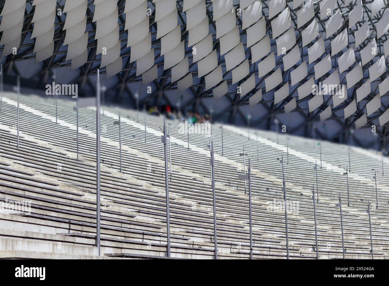 a stage with wooden benches and an acoustic metal wall structure at the ...