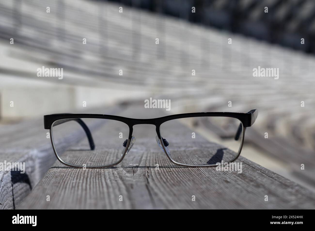 black glasses on a bench in a city park stage Stock Photo - Alamy