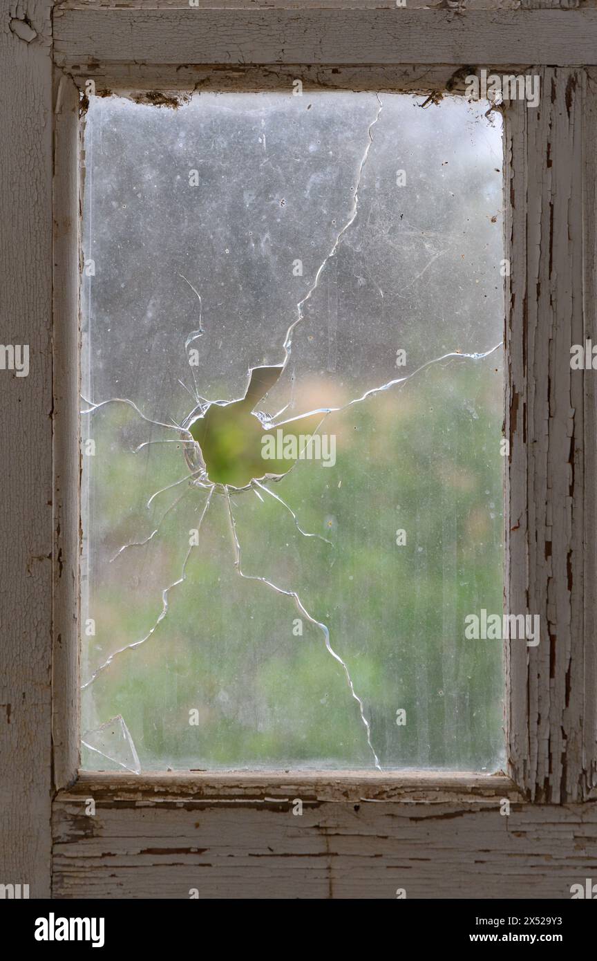 Window with broken glass in old building Wooden window frame with partially broken glass in old ...
