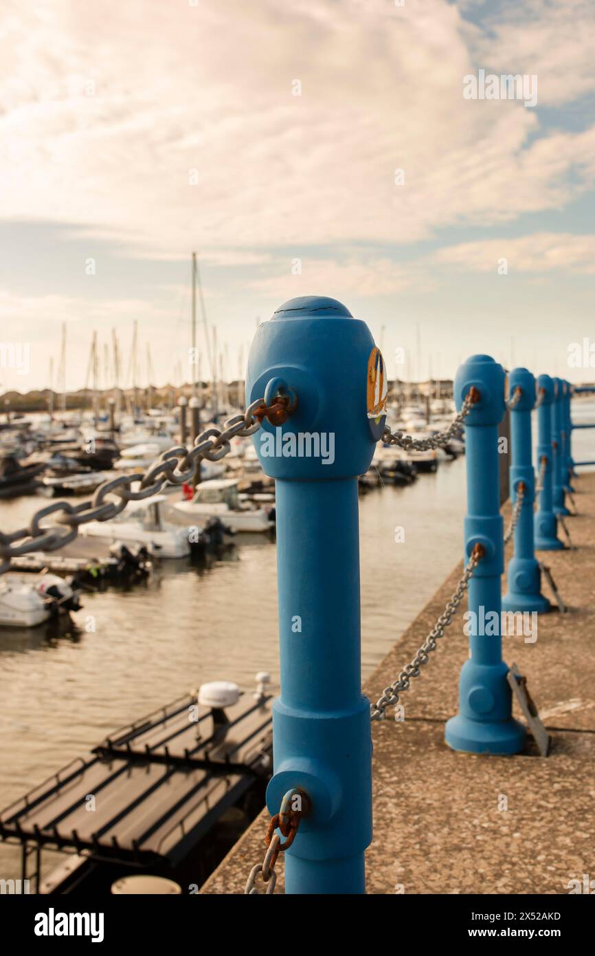 Metal safety posts and chain along the quayside promenade at Pwllheli ...