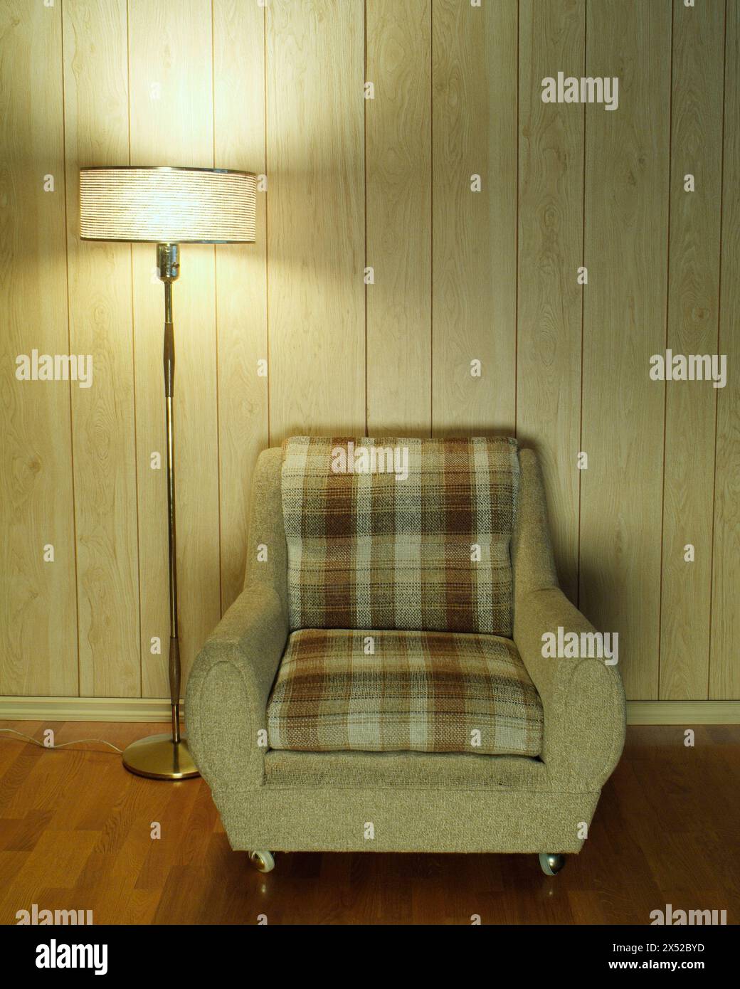 1960's style plaid armchair and vintage floor lamp in unadorned den ...
