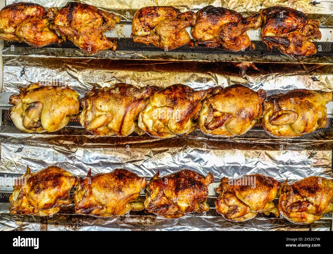 Grilled chickens in spinning rolls at a farmers market in the Provence ...