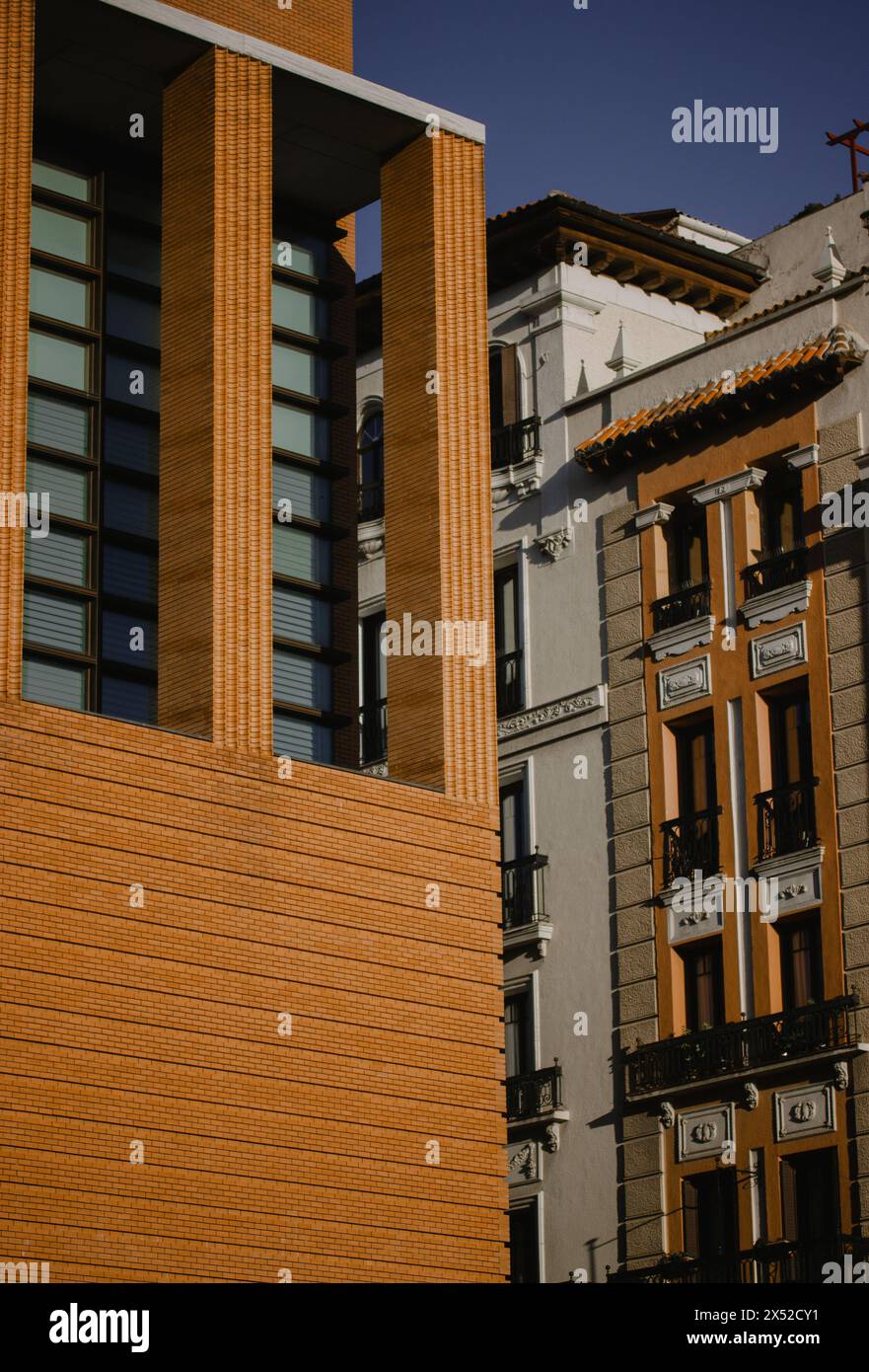 Close up detail of modern orange brick building facade with blue tinted ...