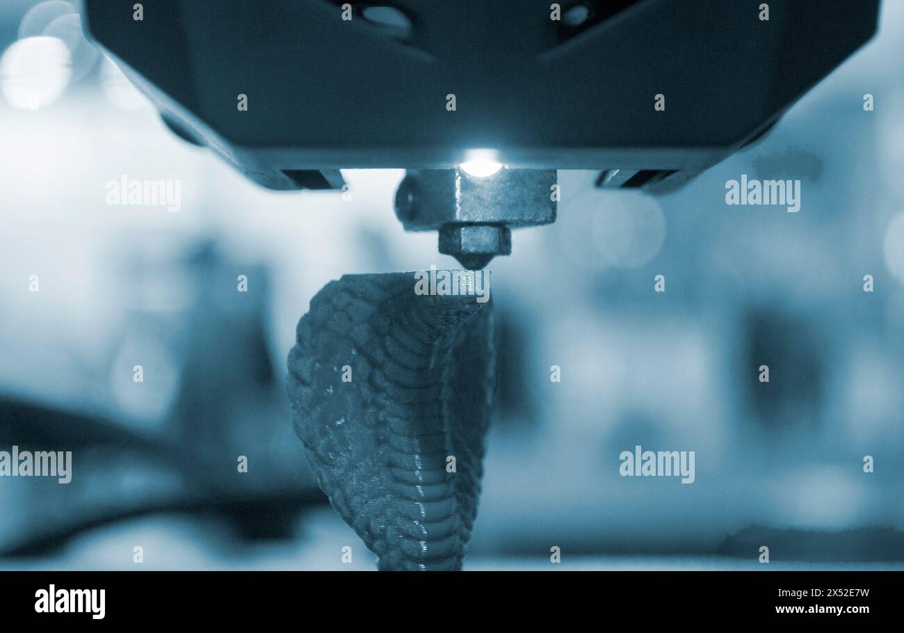3D printer working close-up. 3D printer prints a model from molten ...
