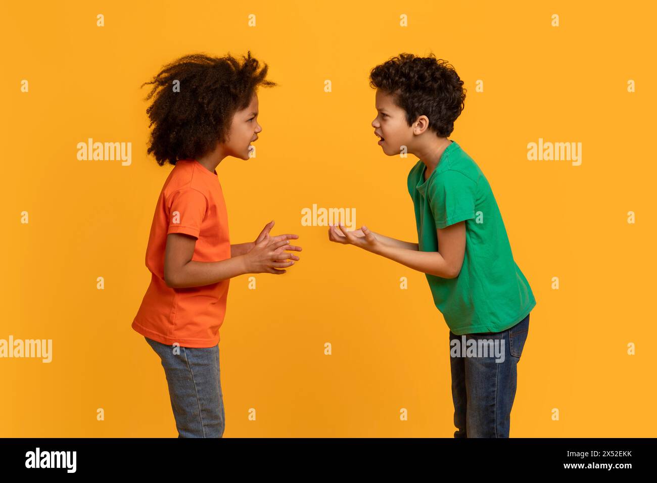 Two Young Children Engaging in Argument Against Bright Yellow ...