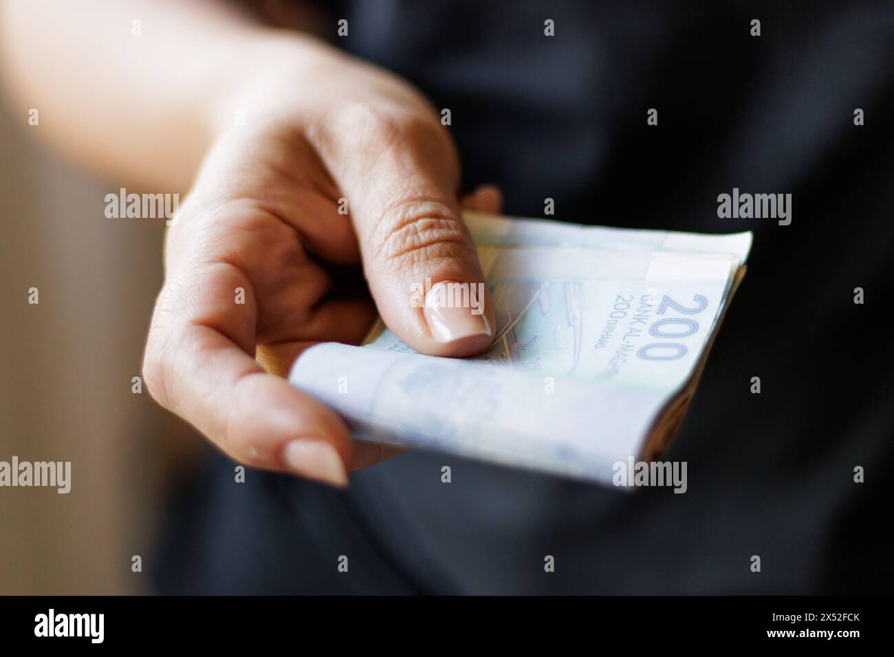 Hand holding Moroccan banknotes, dirham official currency of Morocco ...