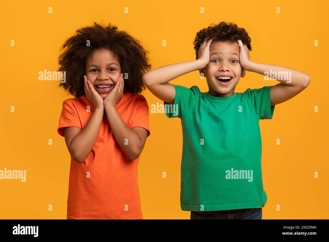 Two Joyful Children Expressing Surprise and Delight on Yellow Stock ...
