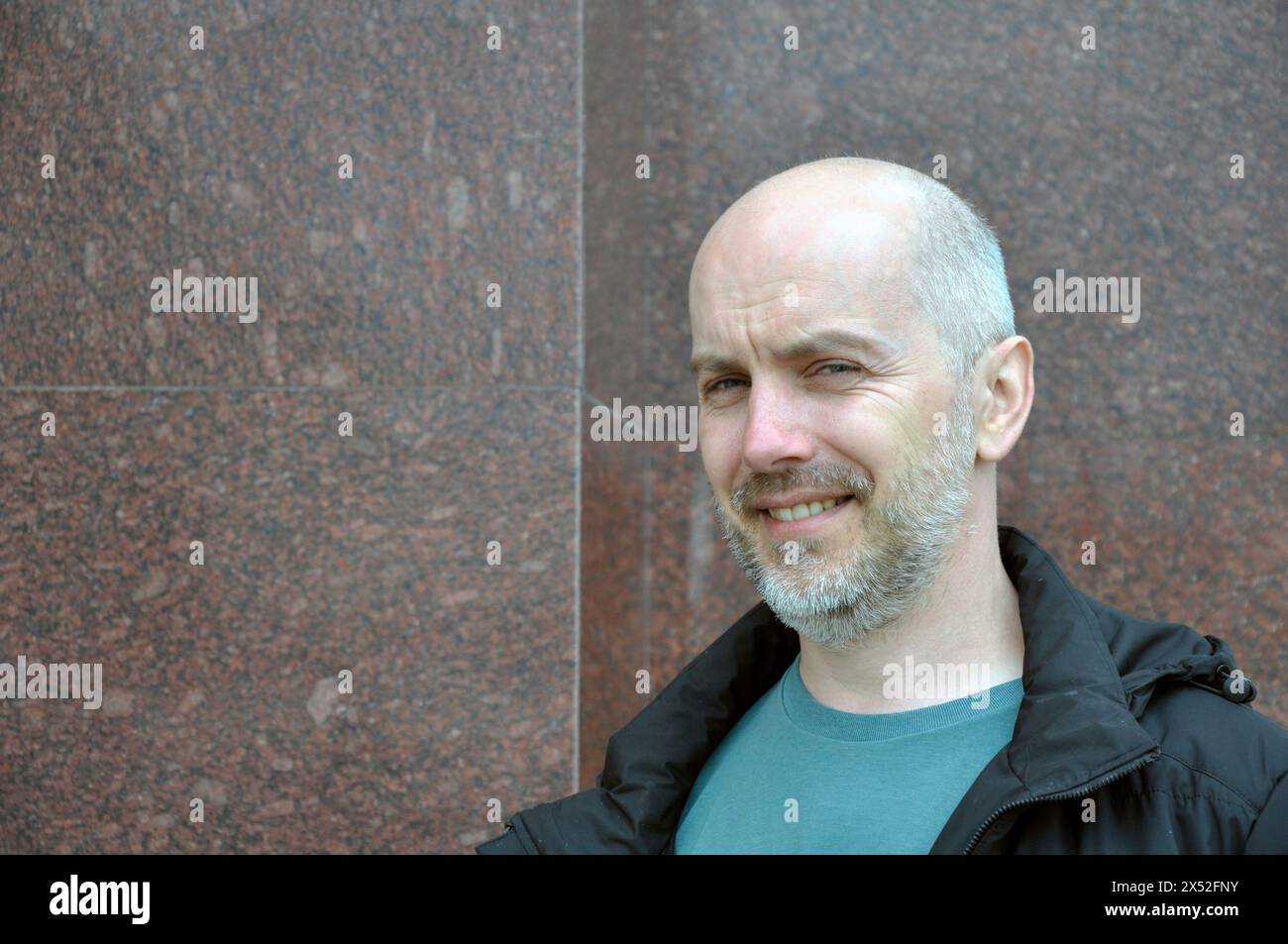 Close-up portrait of a smiling unshaven village guy in dirty clothes ...
