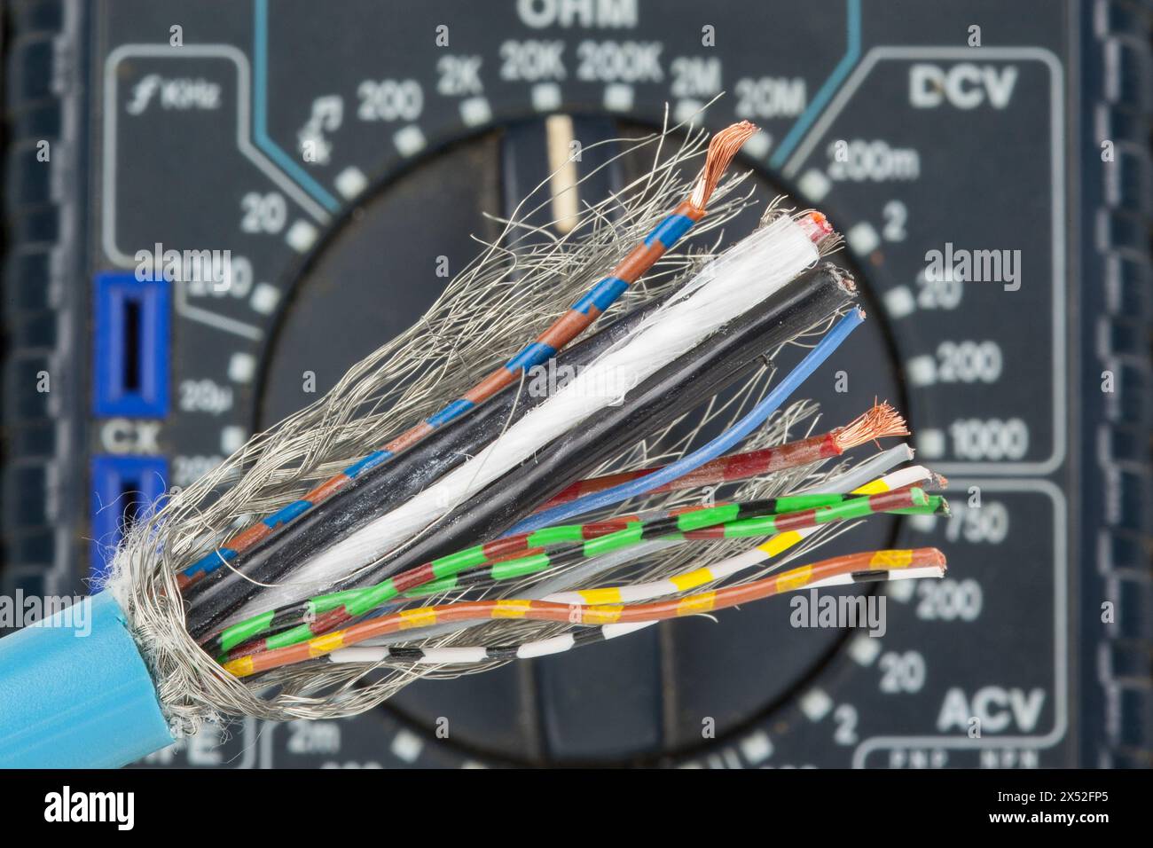 Stripped cable with several colors in front of the scale of a ...