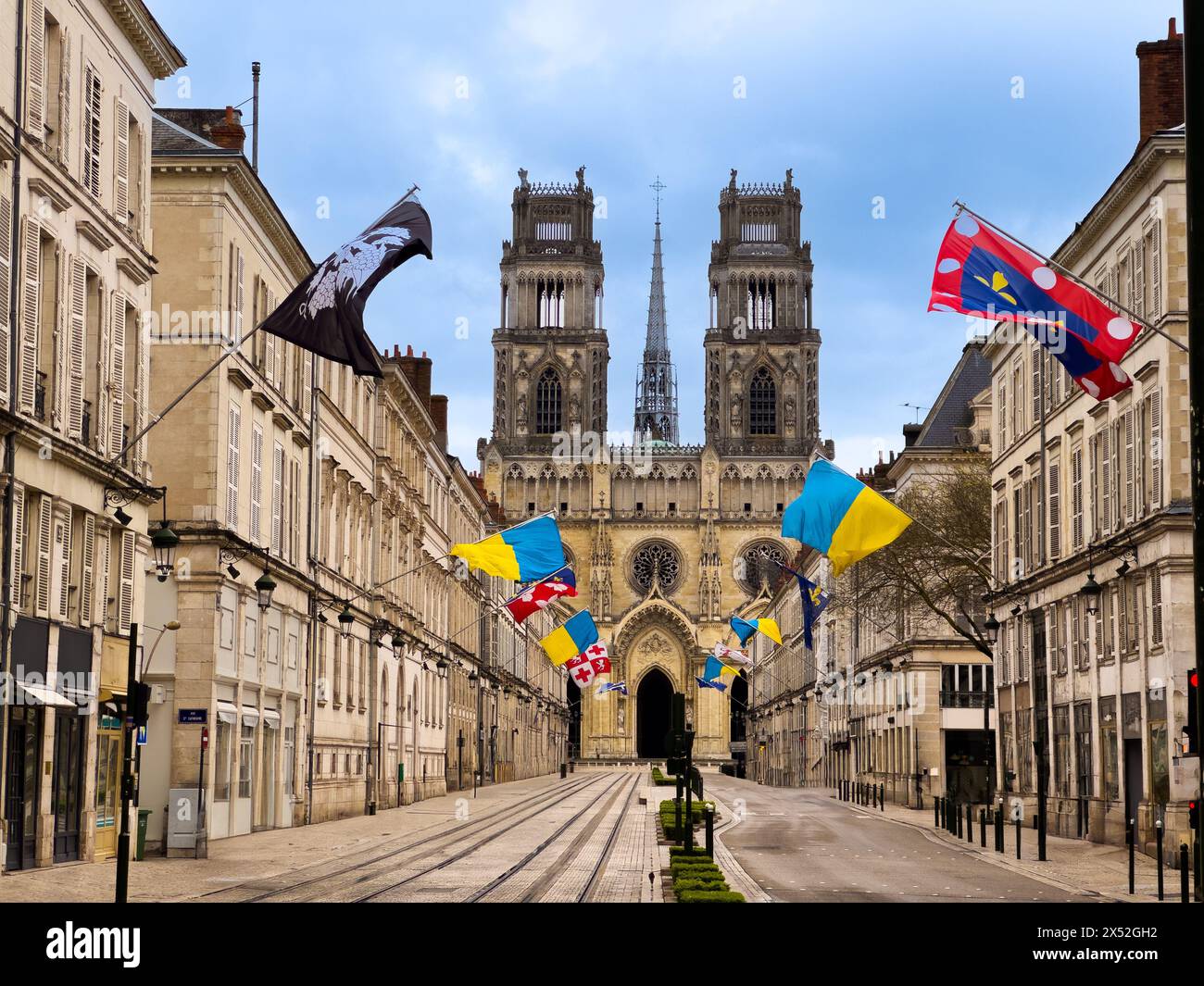 Street Joan of Arc with flags leading to majestic Gothic church Stock ...