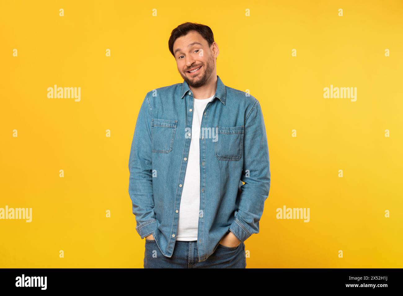 Man Standing in Front of Yellow Background, Hands in Pockets Stock ...