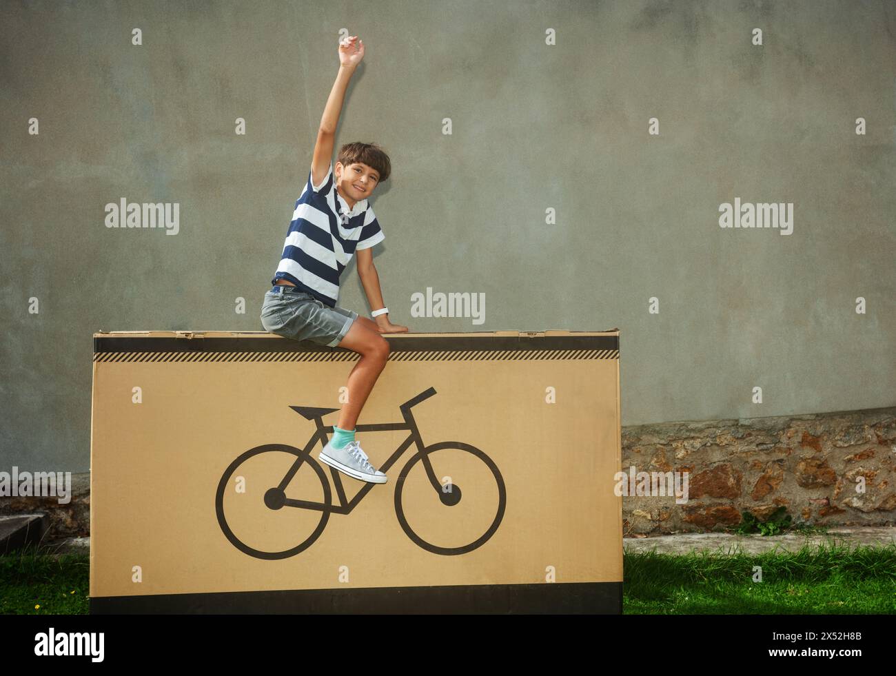 Happy teenage boy on bike gift box triumphantly raising arms Stock ...