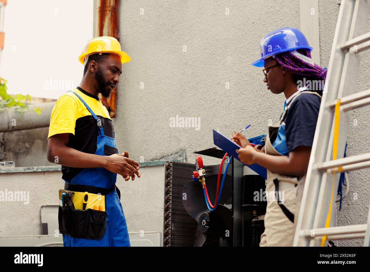 Seasoned mechanics repairing heating and ventilation of air ...