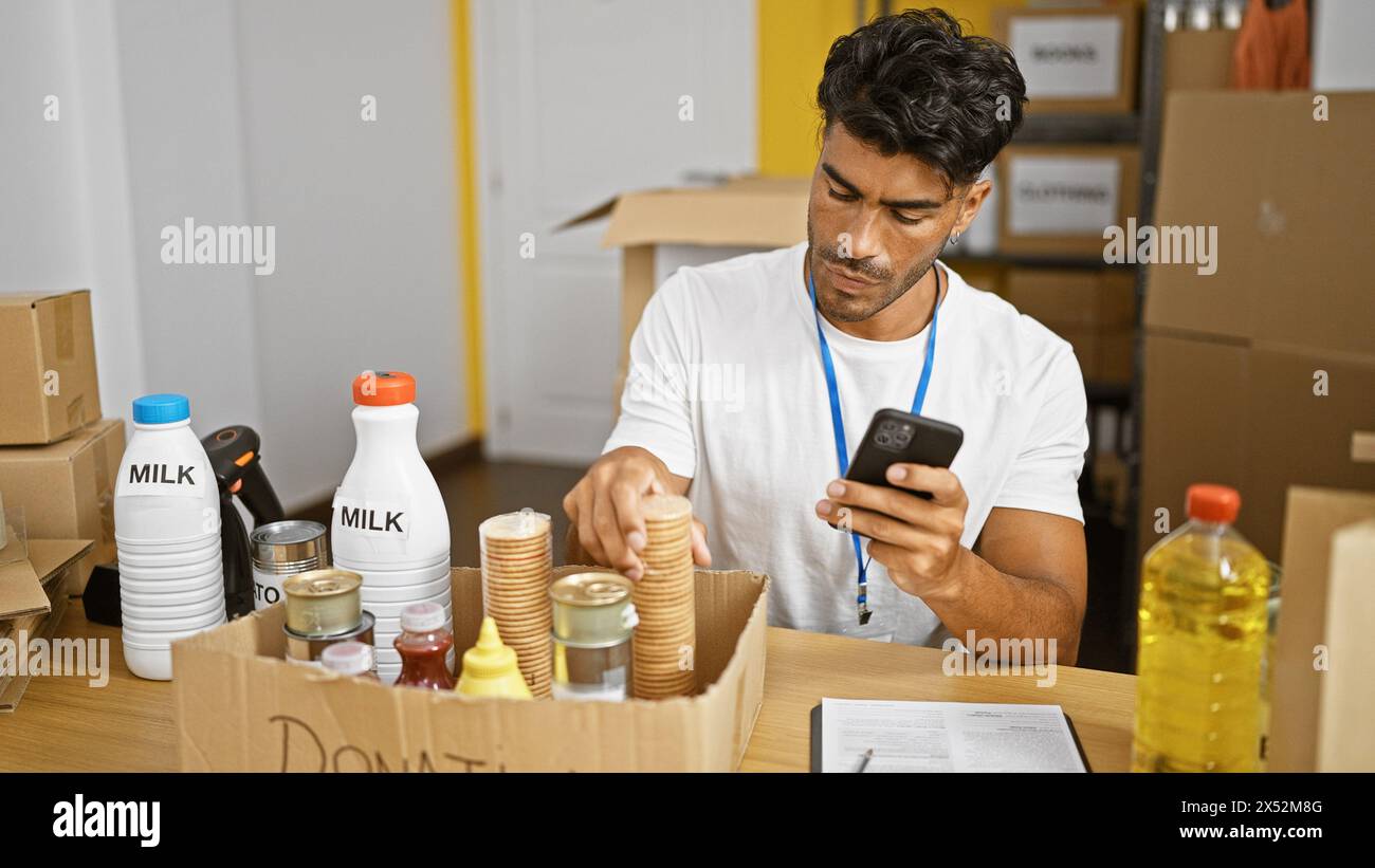 Handsome hispanic man counting stock in a warehouse, using a smartphone ...
