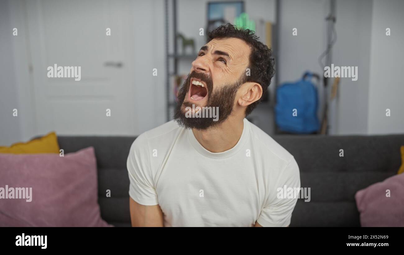 Bearded man screaming in a living room with a sofa Stock Photo - Alamy