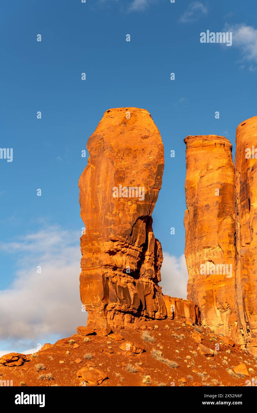 Mountainside lit up by a rising sun casts an orange color against the ...