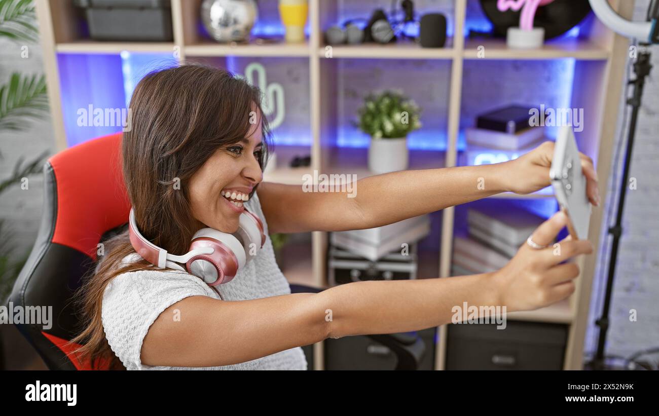Attractive young hispanic woman streamer smiling, making selfie with ...