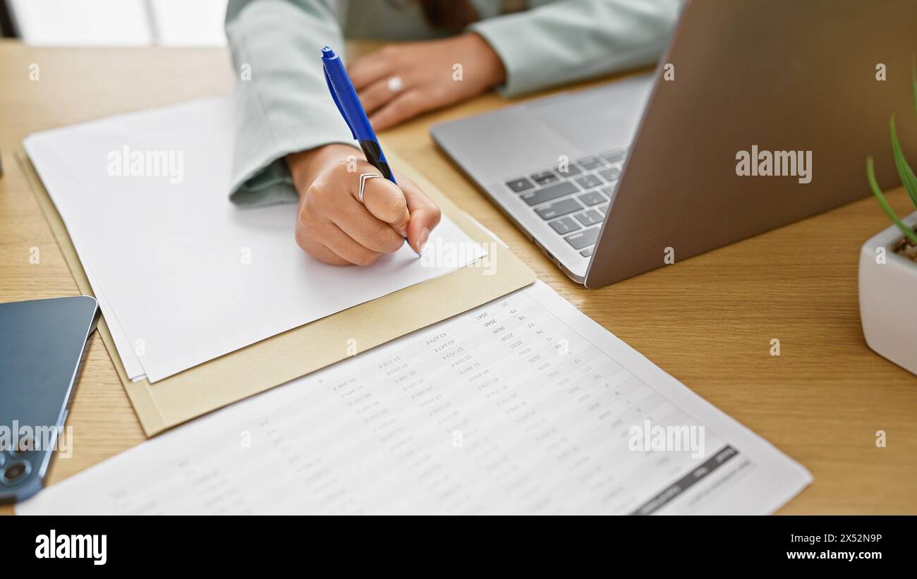 Behind the scenes, young hispanic female executive's hands at work ...