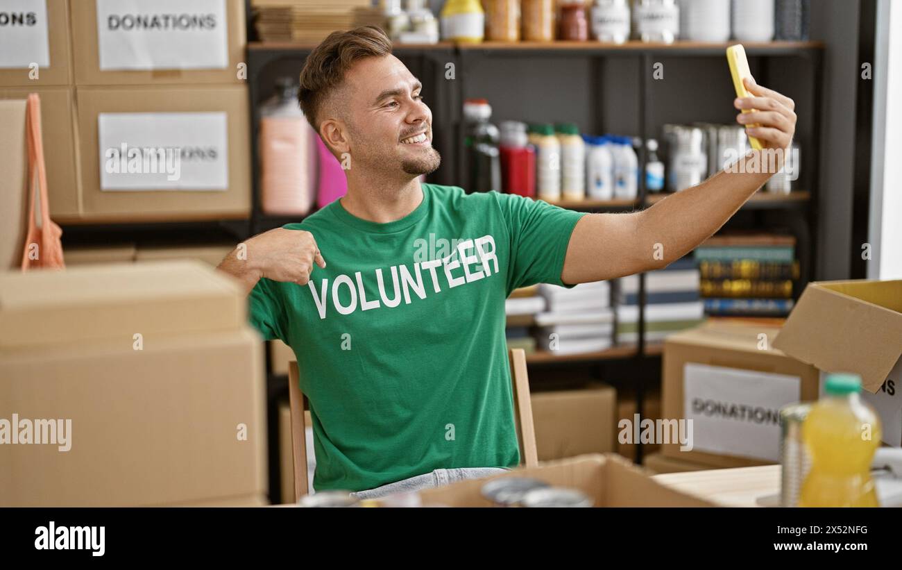 Smiling hispanic man takes selfie in a warehouse full of donation boxes ...