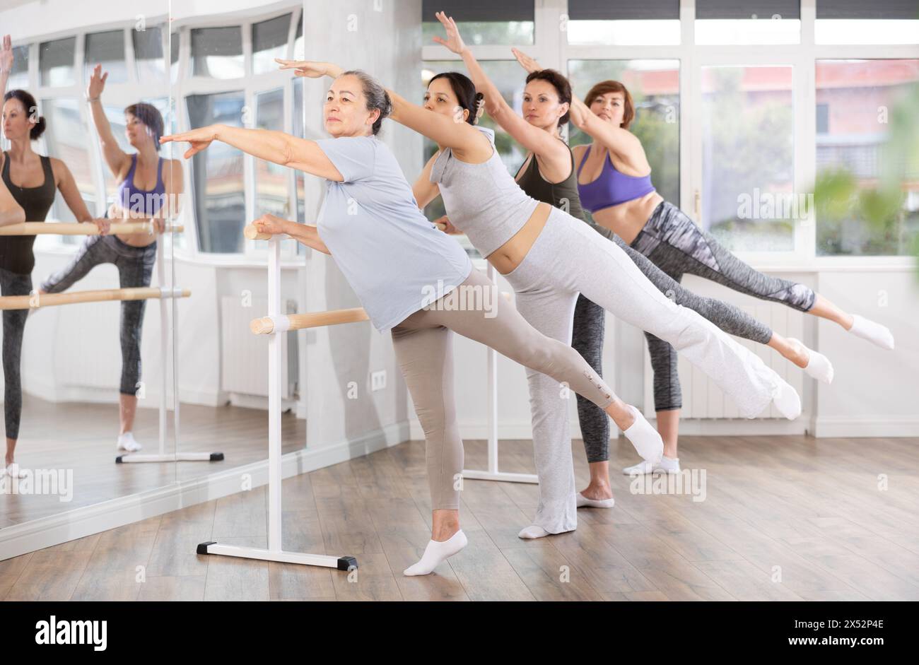 Elderly woman practicing arabesque in beginner ballet group Stock Photo ...