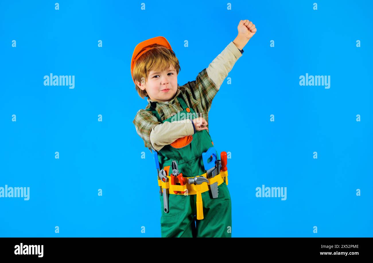 Little builder in construction helmet and tool belt. Kid repairman in ...
