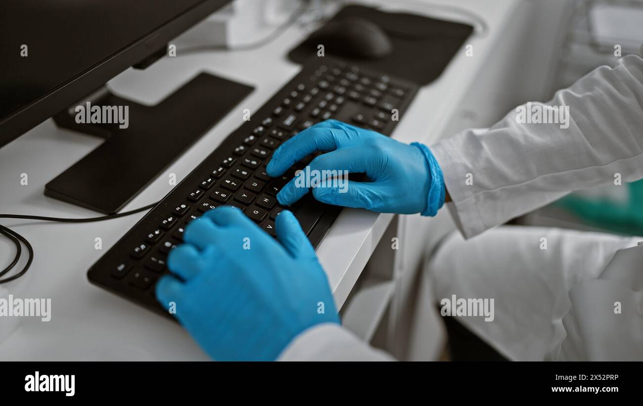 Healthcare professional in blue gloves typing on a keyboard in a modern ...