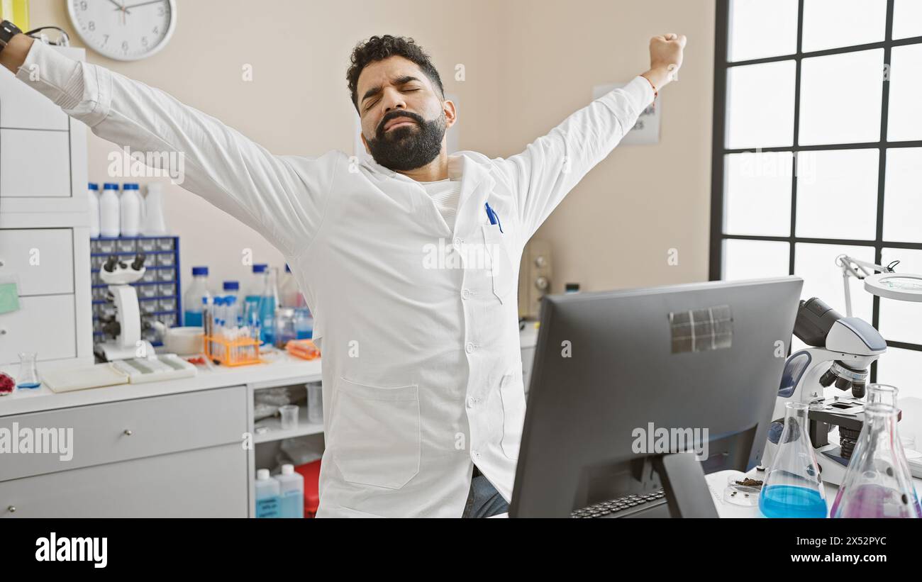 A young hispanic man stretches in a modern laboratory setting, showing ...