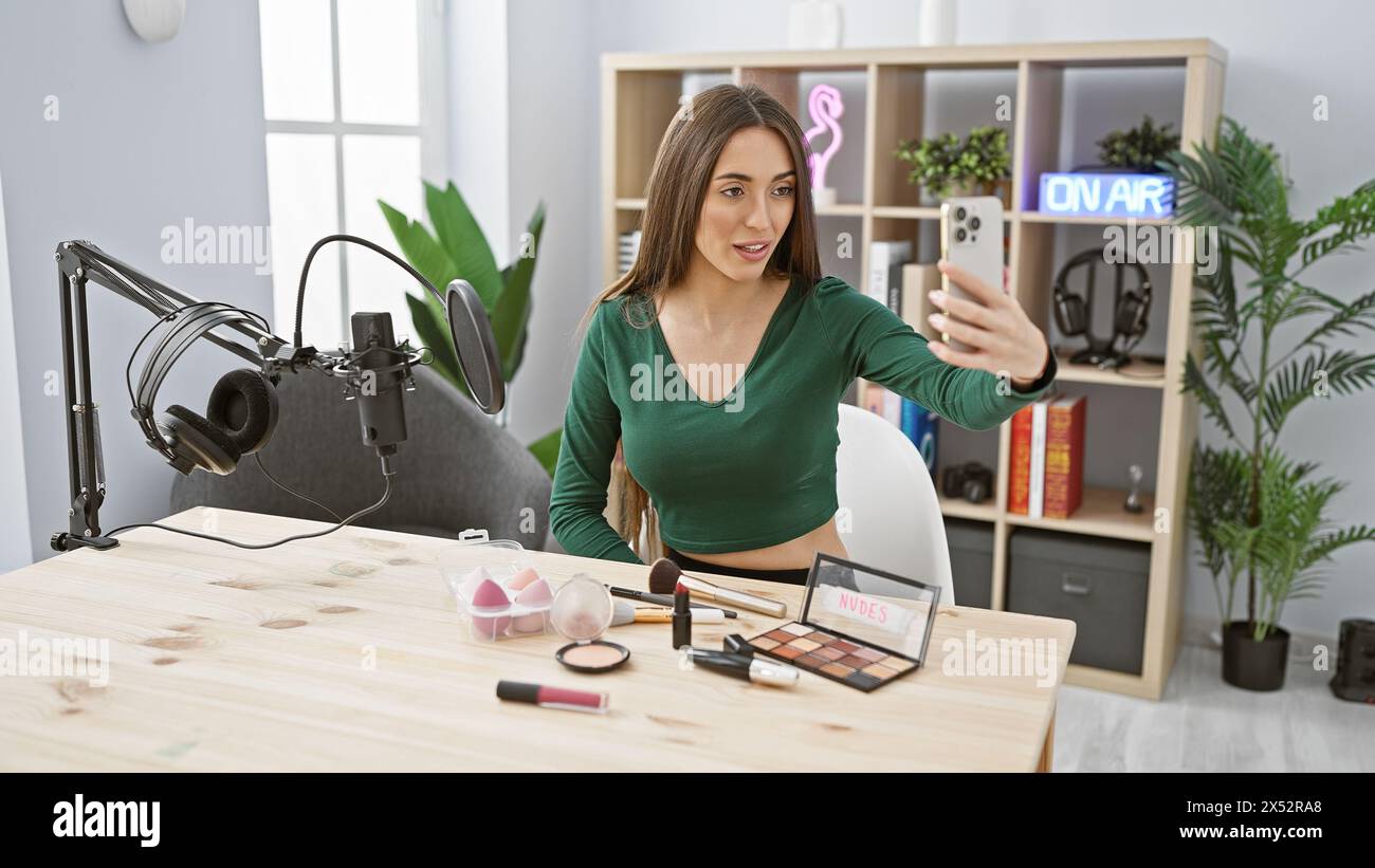 Woman podcasting in studio with microphone taking selfie surrounded by ...