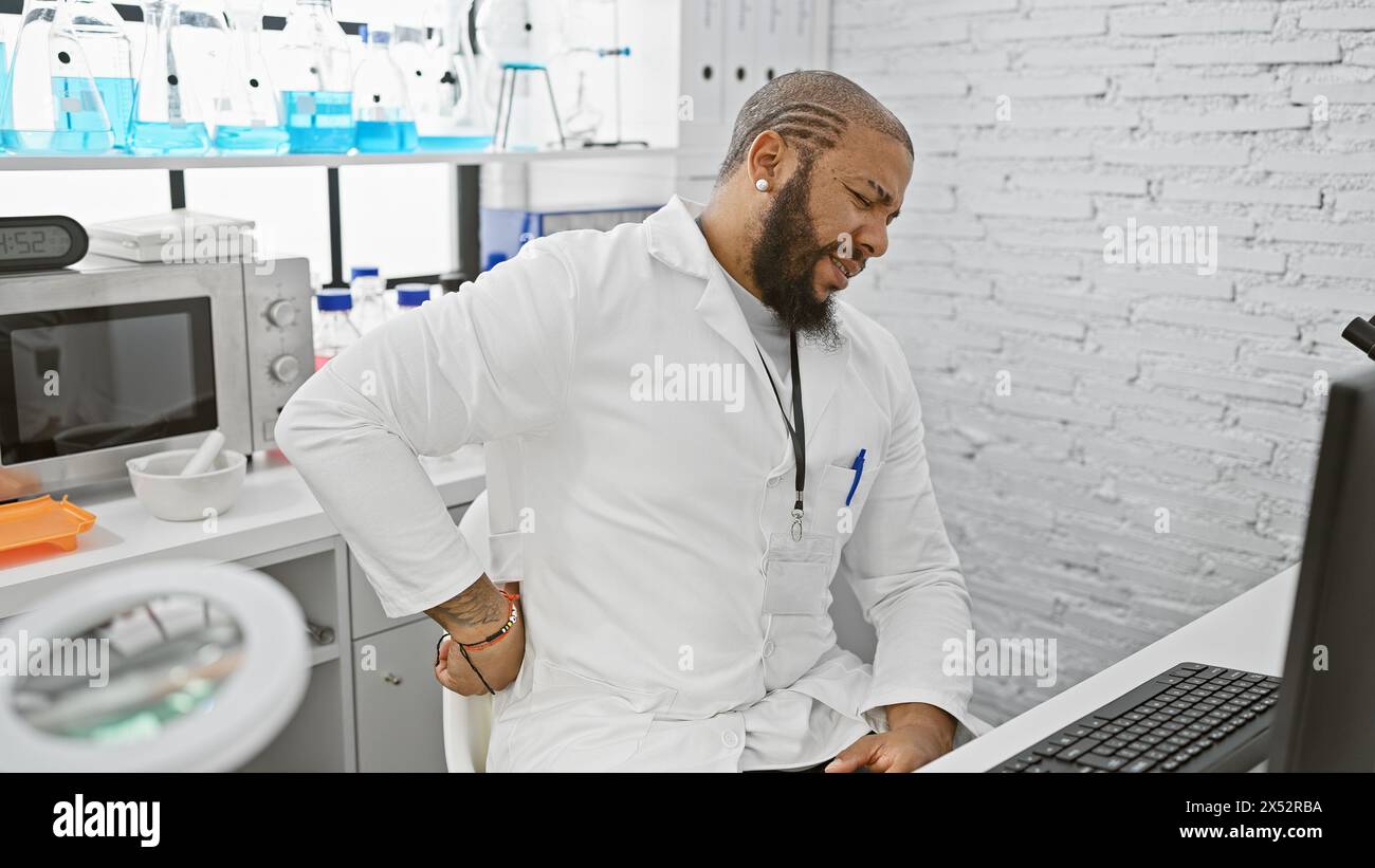 African american male scientist in lab coat wincing in pain at ...