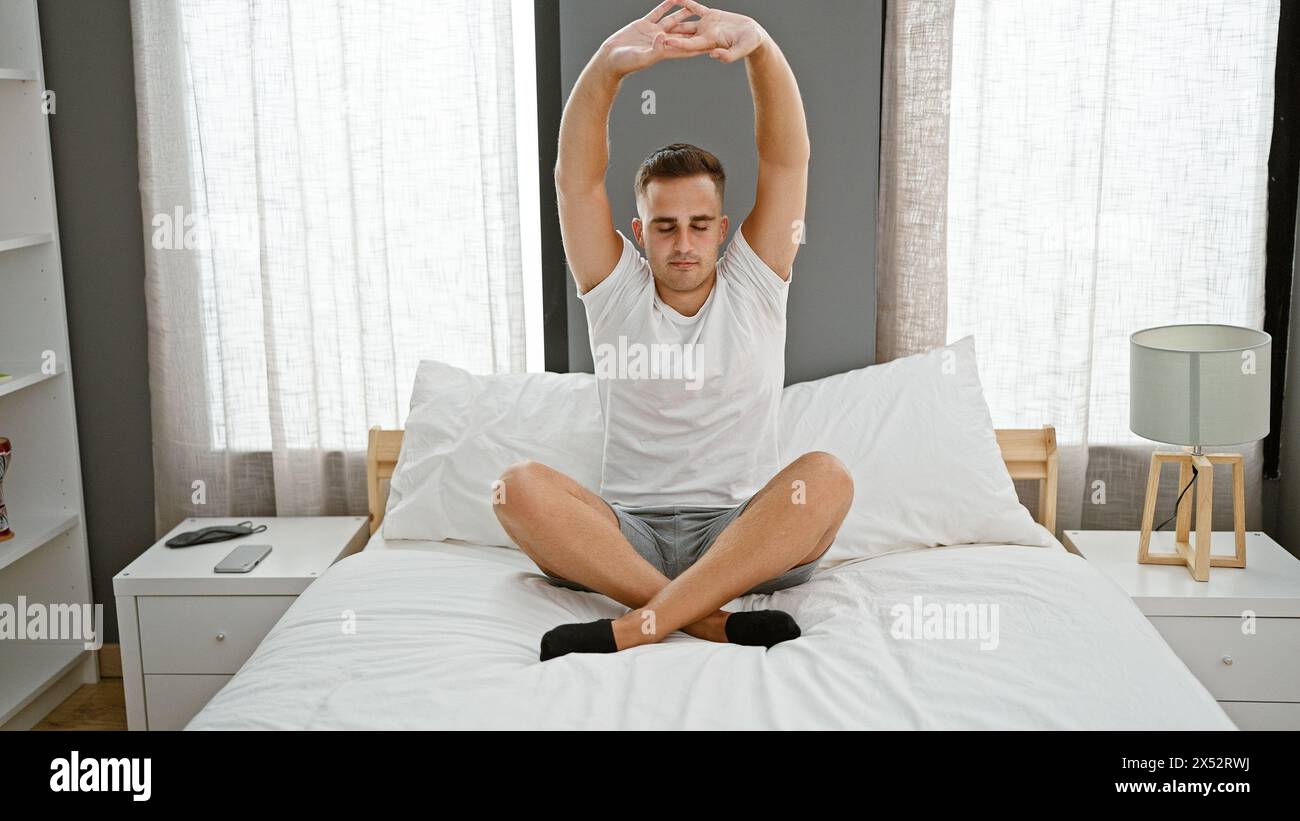 Young man stretching in a minimalist bedroom with natural light ...
