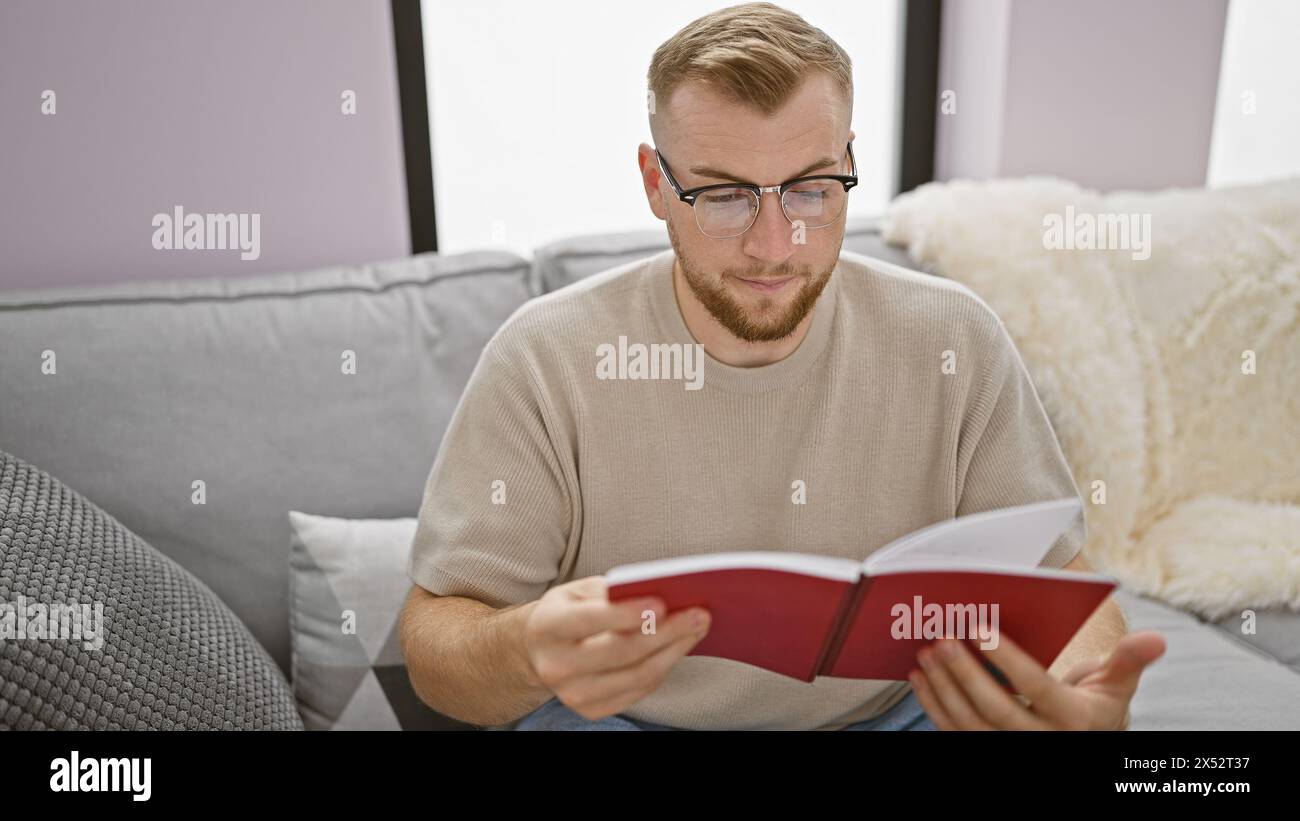 Handsome man reading book comfortably relaxed in a modern living room ...