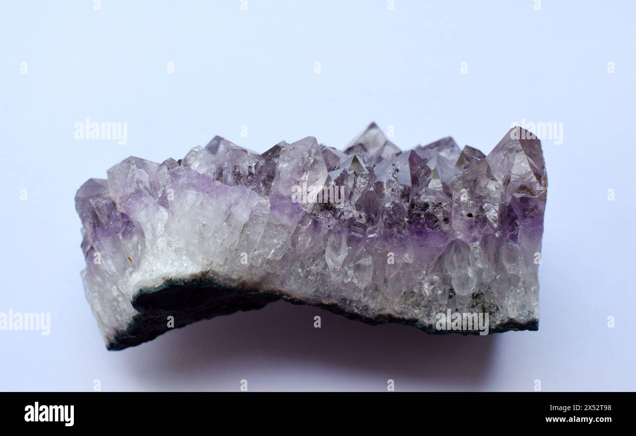 Beautiful druse of natural purple mineral amethyst on a white ...