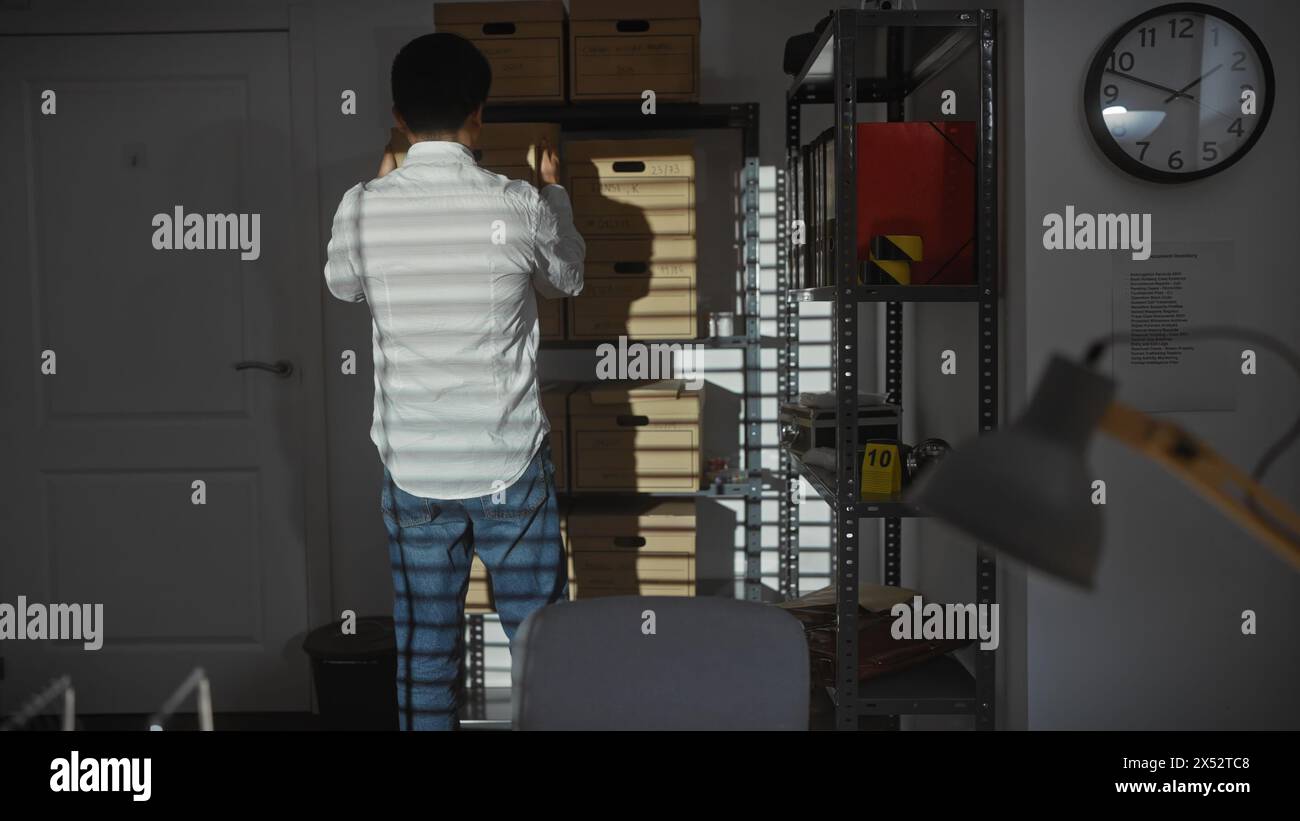 Young asian man organizing files in a police department evidence room ...