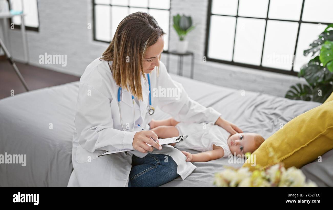 Cool and serious female doctor lovingly examining baby patient, reading ...