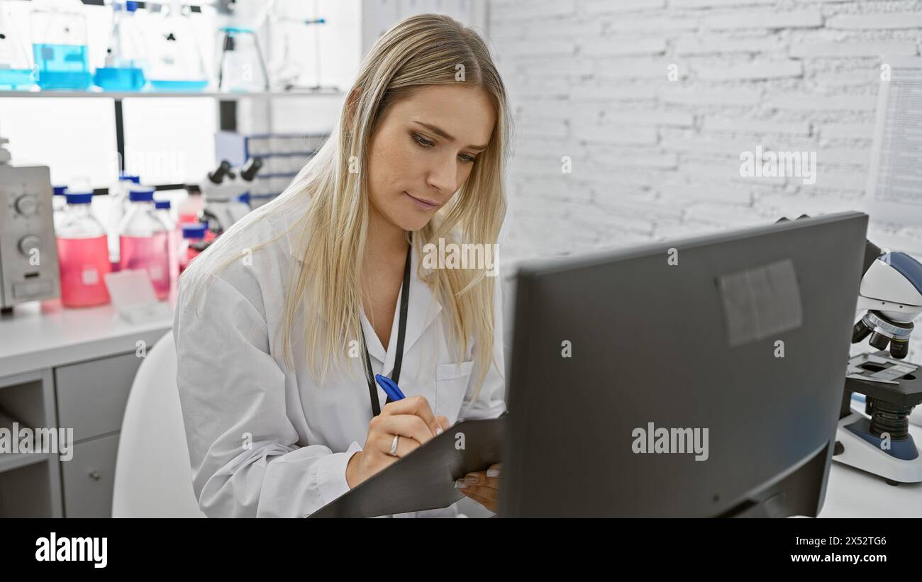 Attractive young blonde female scientist seriously immersed in research ...